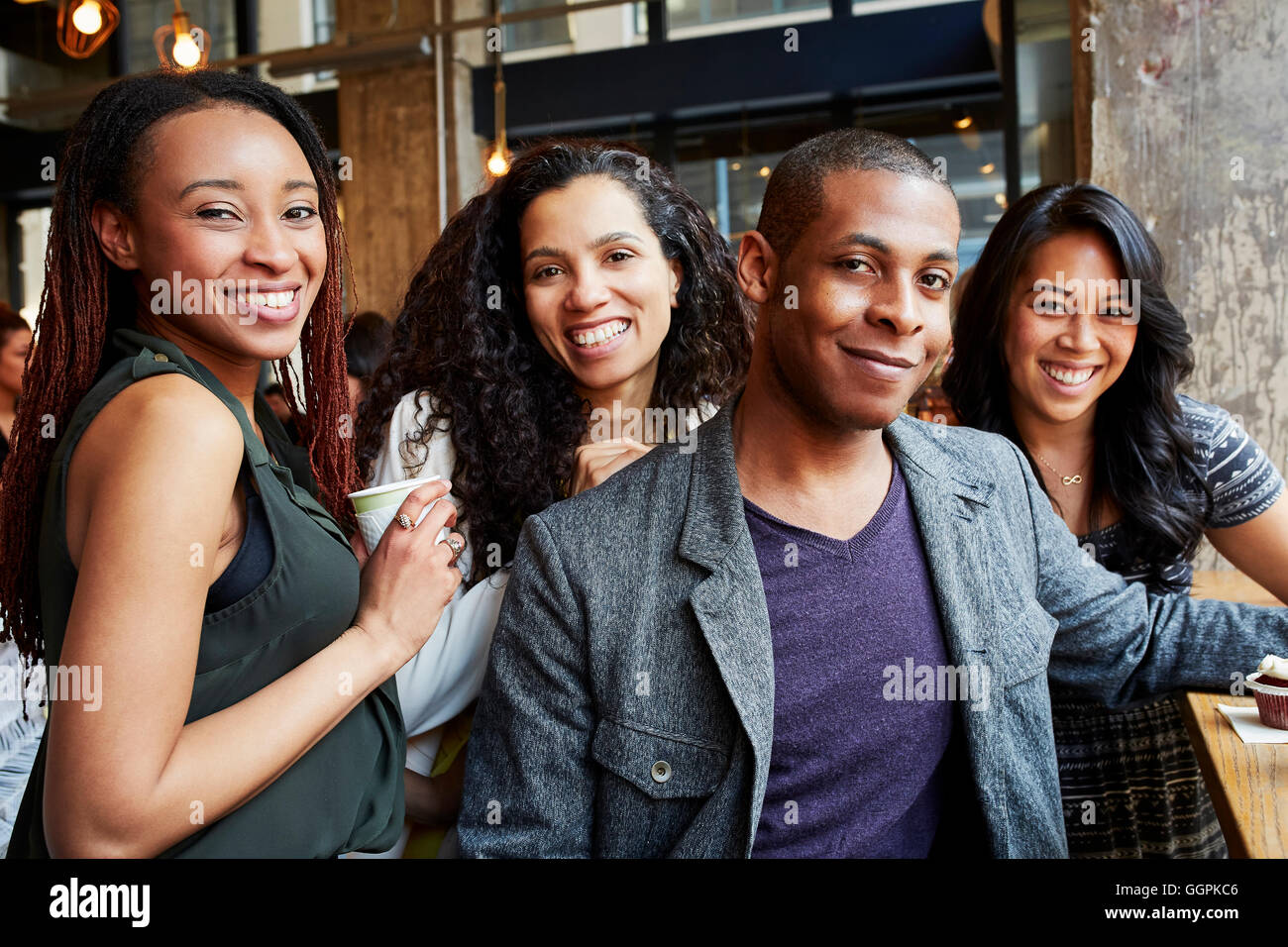 Friends smiling in cafe Stock Photo - Alamy