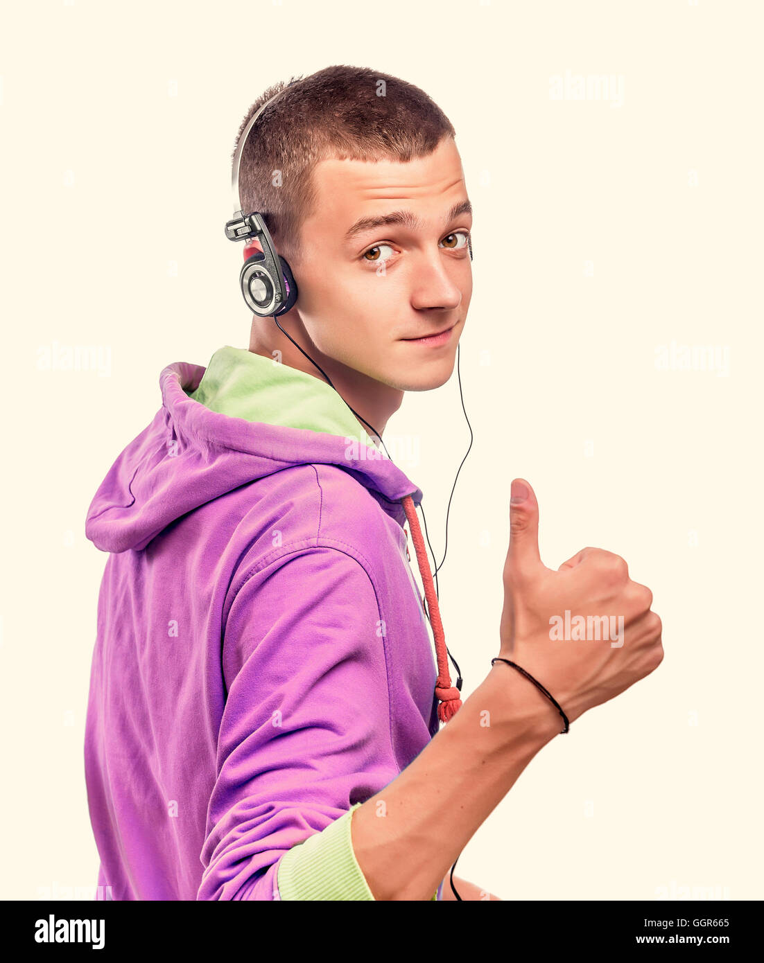 Handsome guy with headphones showing thumbs up. Toned photo Stock Photo ...