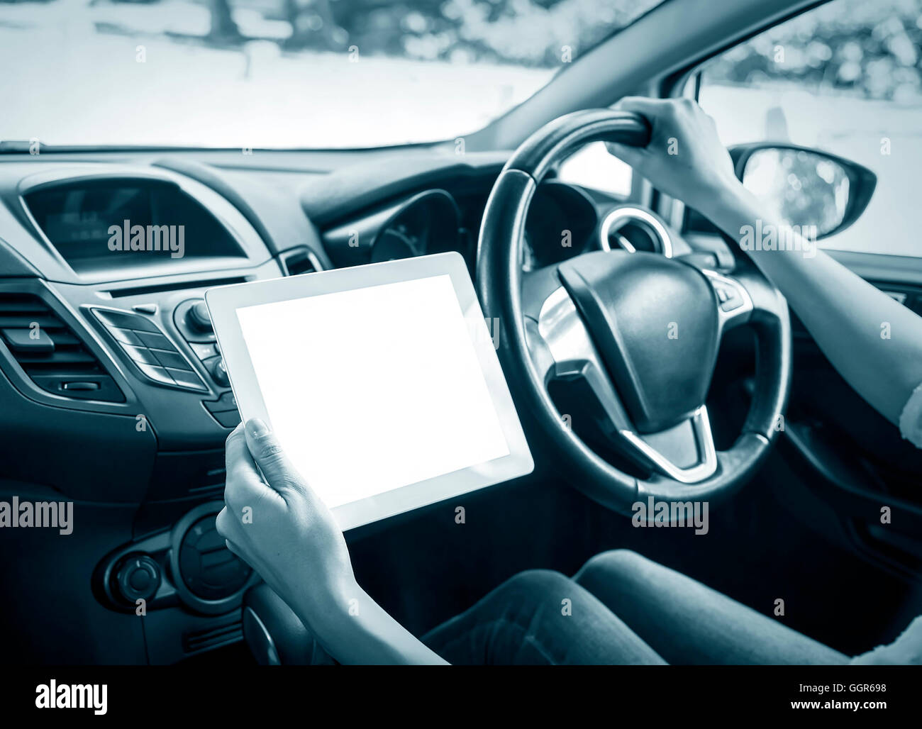 Using a tablet computer driving a modern car Stock Photo - Alamy