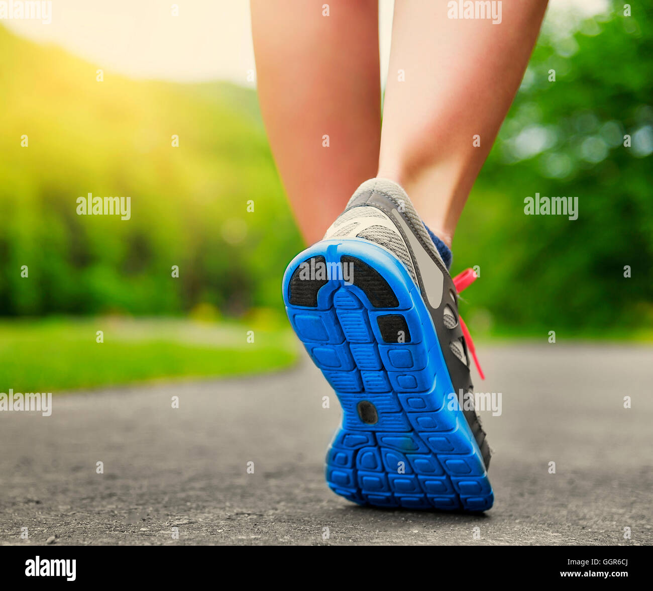 Woman's legs in shoes on runner jogging in the park at sunset Stock ...