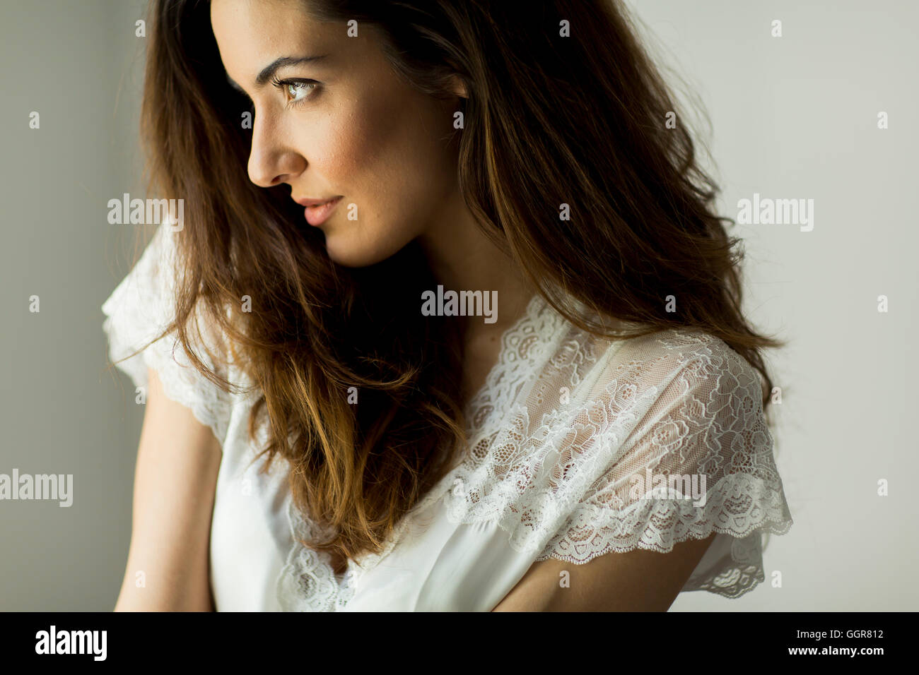 Pretty young woman by the window in the room Stock Photo - Alamy