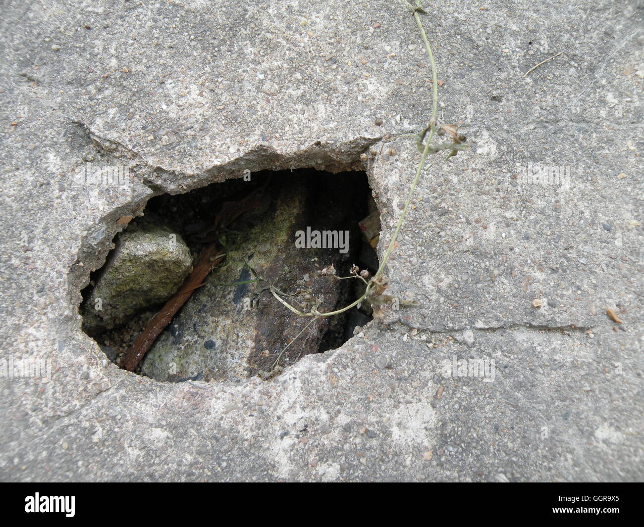 Uneven, rough textured concrete with random shaped hole revealing ...