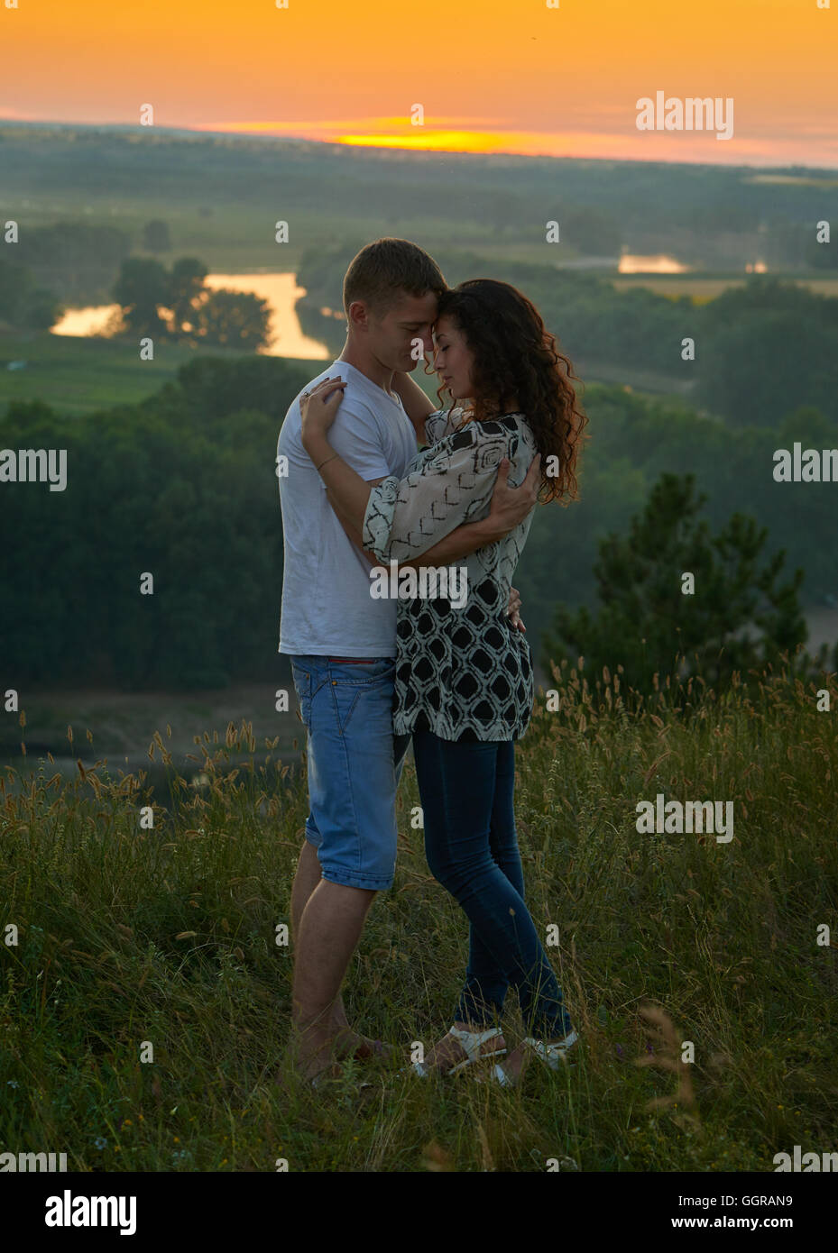 romantic couple embrace at sunset on outdoor, beautiful landscape and ...