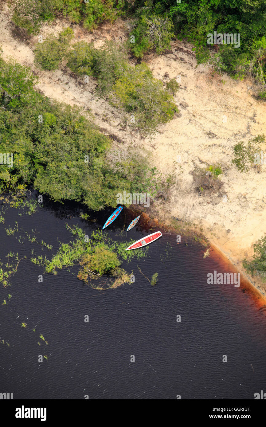 Aerial view of boats on a black-water river beach in the Brazilian ...