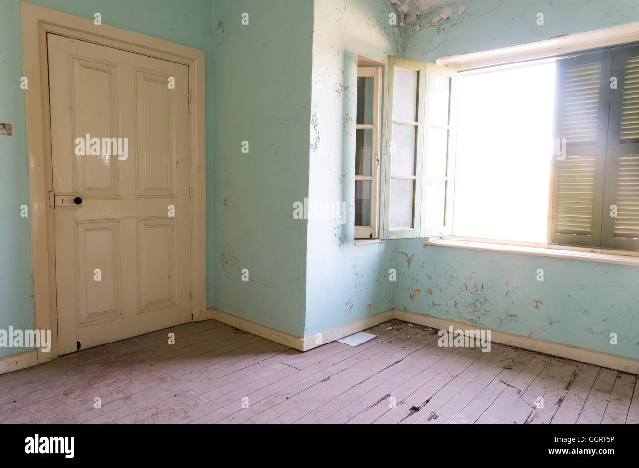 Interior of a dirty damaged abandoned room with open windows and closed ...