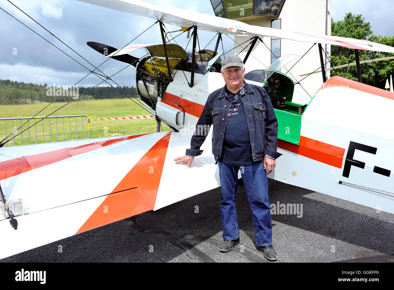 the pilot in front of his biplane ready for takeoff at the airport ...