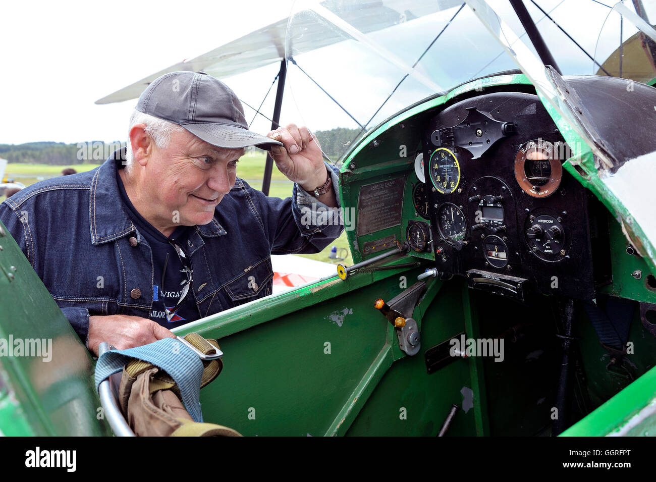 the pilot in front of his biplane ready for takeoff at the airport ...