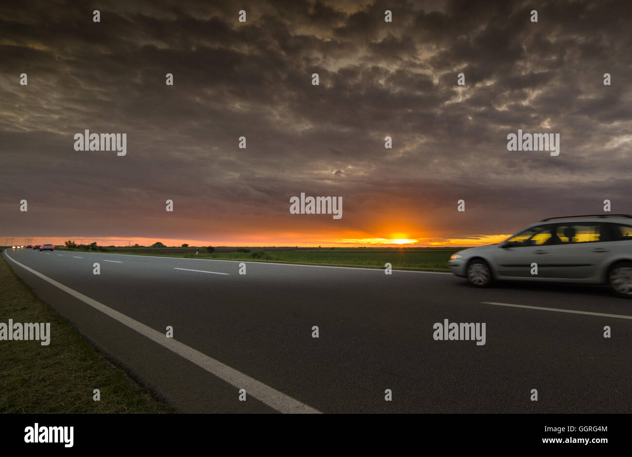 Car driving on freeway at sunset Stock Photo - Alamy
