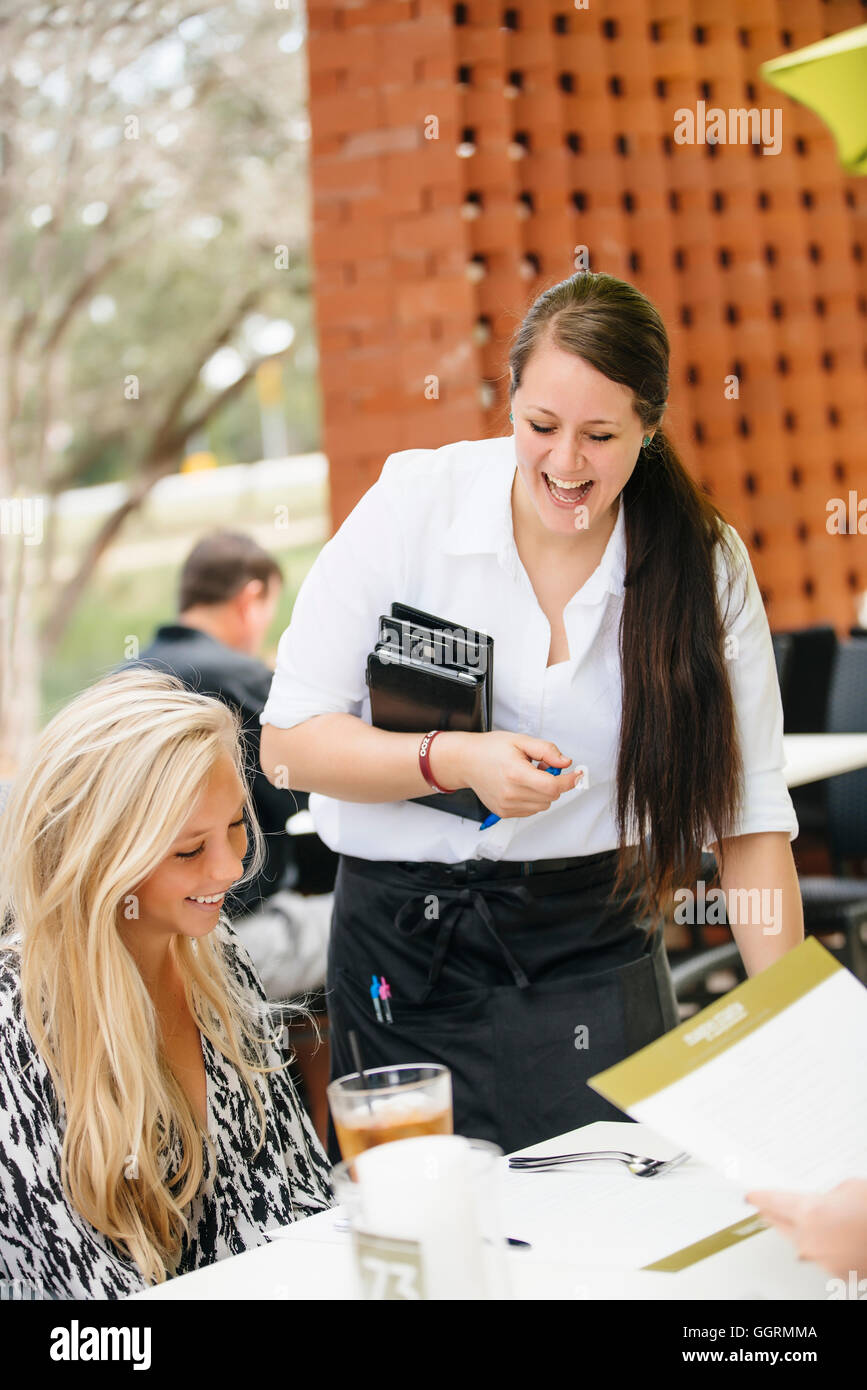 Smiling Caucasian waitress assisting customer Stock Photo - Alamy