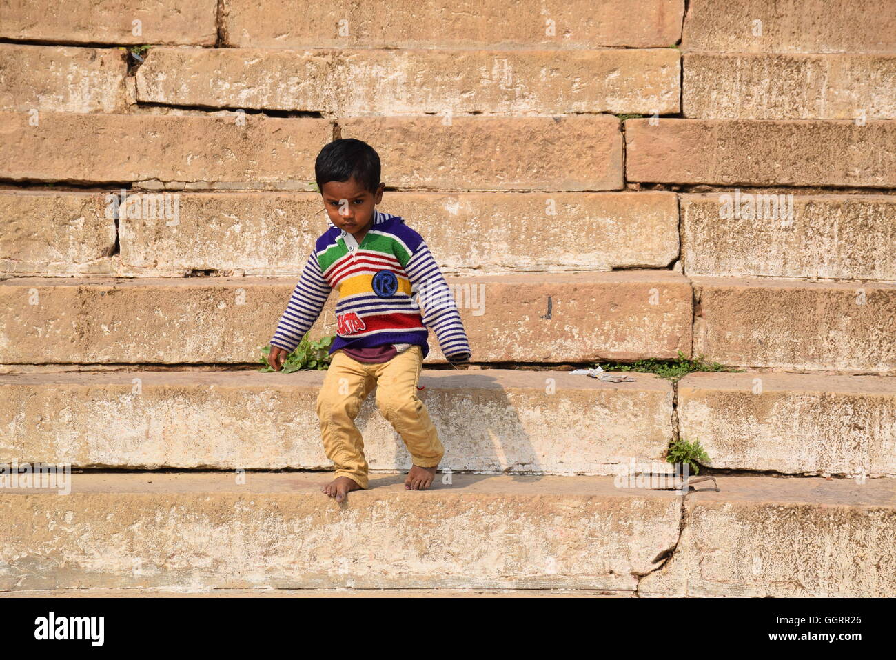 Indian baby going down the steps of the ghats in Varanasi, Uttar ...