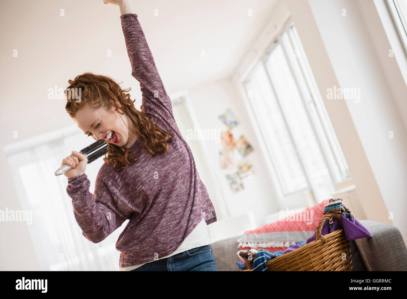 Caucasian woman singing with hairbrush microphone Stock Photo - Alamy
