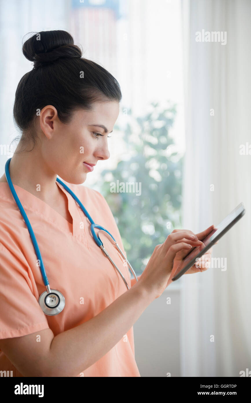 Caucasian nurse using digital tablet Stock Photo - Alamy