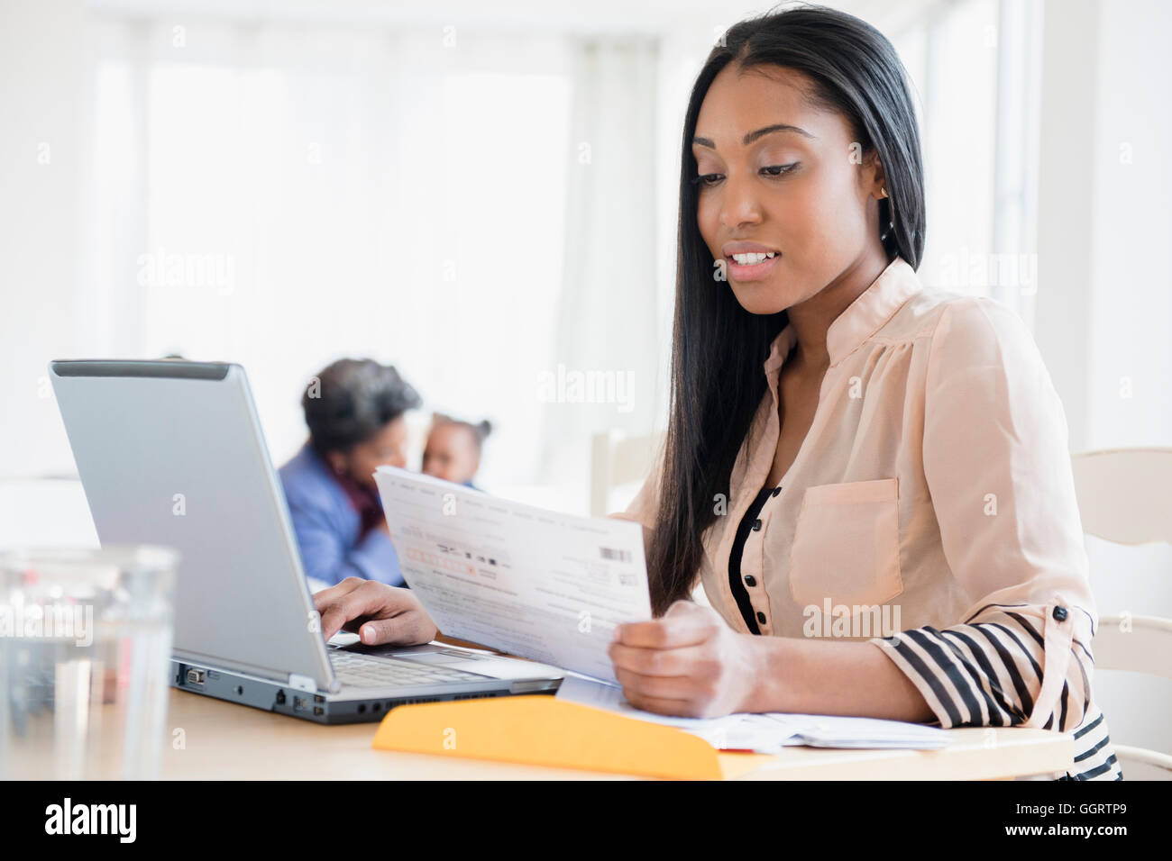 Black woman paying bills using laptop Stock Photo - Alamy