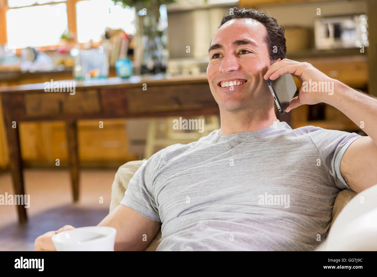 Hispanic man laying on sofa using cell phone Stock Photo - Alamy