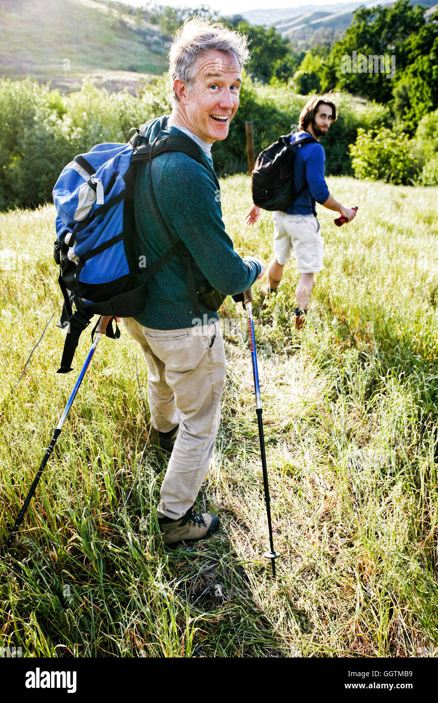 Caucasian men hiking in grass on mountain Stock Photo - Alamy