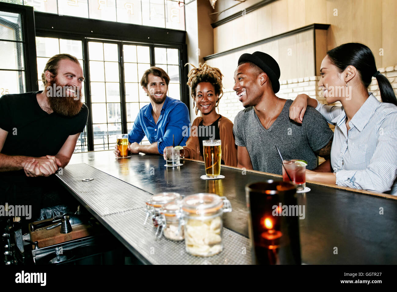 Smiling bartender and customers at bar Stock Photo - Alamy