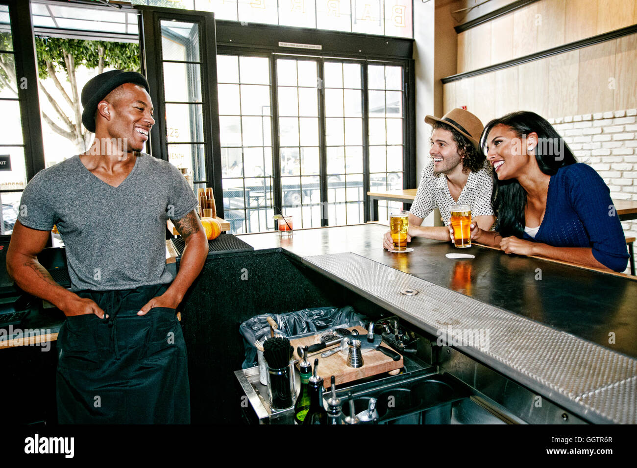 Smiling bartender and customers at bar Stock Photo - Alamy