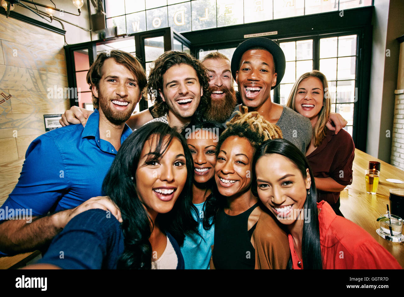 Smiling friends posing in bar Stock Photo - Alamy