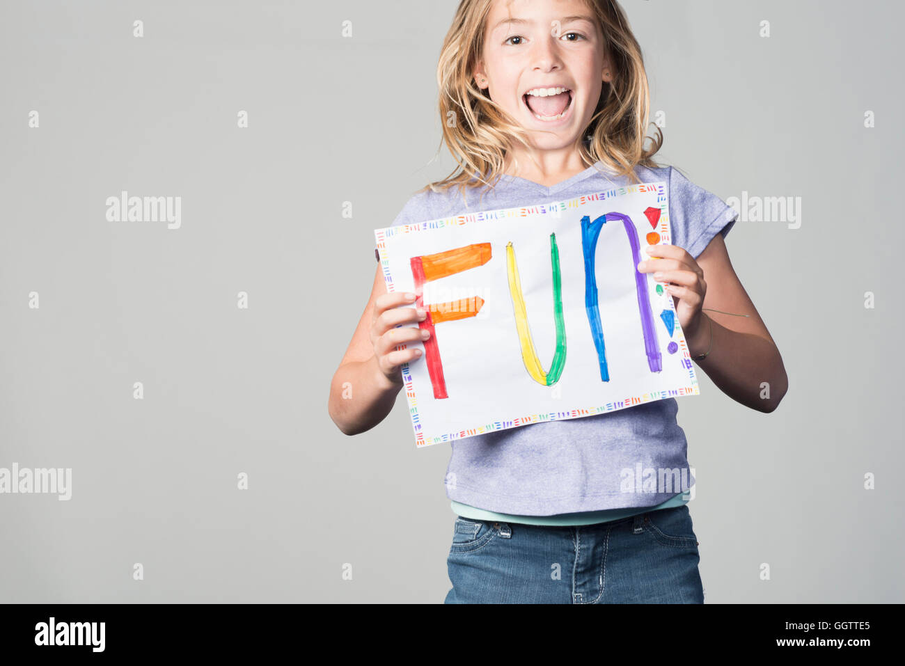 Happy Mixed Race girl holding fun sign Stock Photo - Alamy