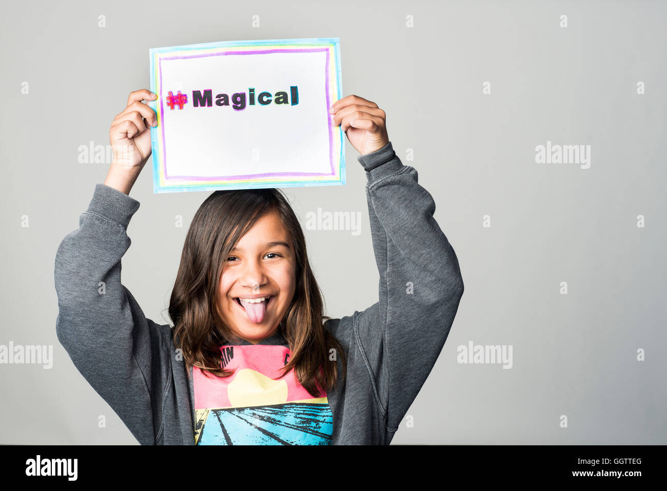 Hispanic girl holding magical sign above head Stock Photo - Alamy