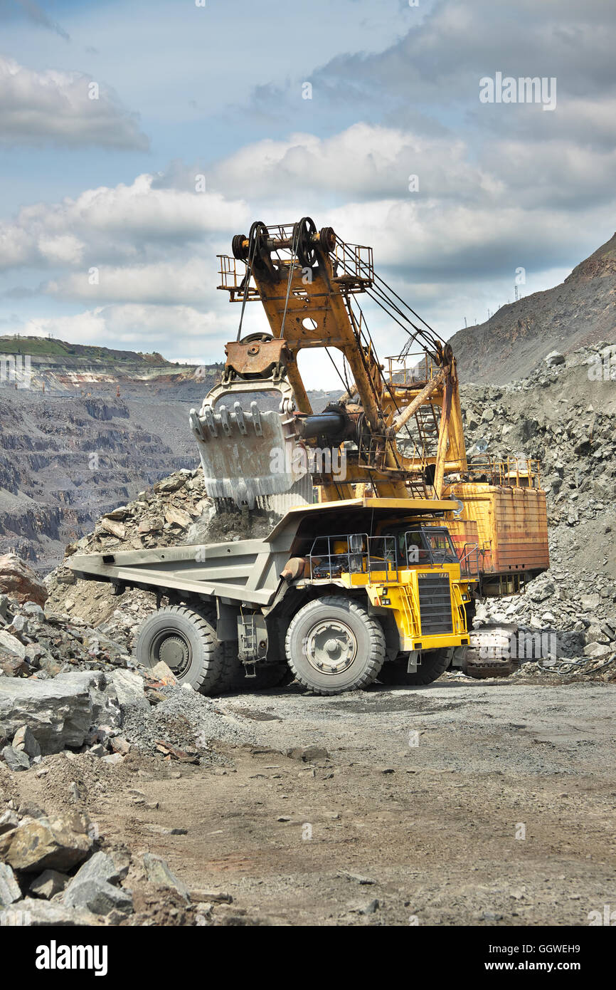 Iron ore mining - excavator is loading the dump truck on the opencast ...