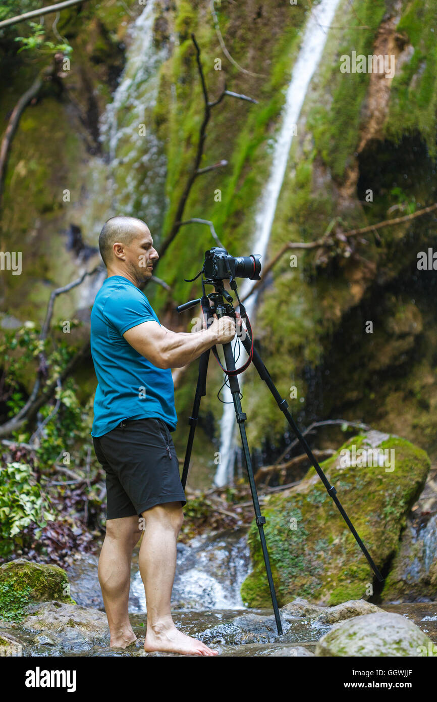 Professional landscape photographer with camera on tripod shooting a ...