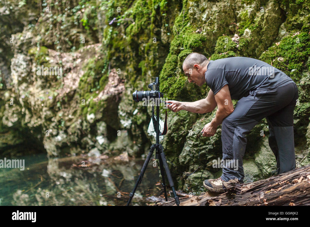 Professional landscape photographer with camera on tripod by the lake ...