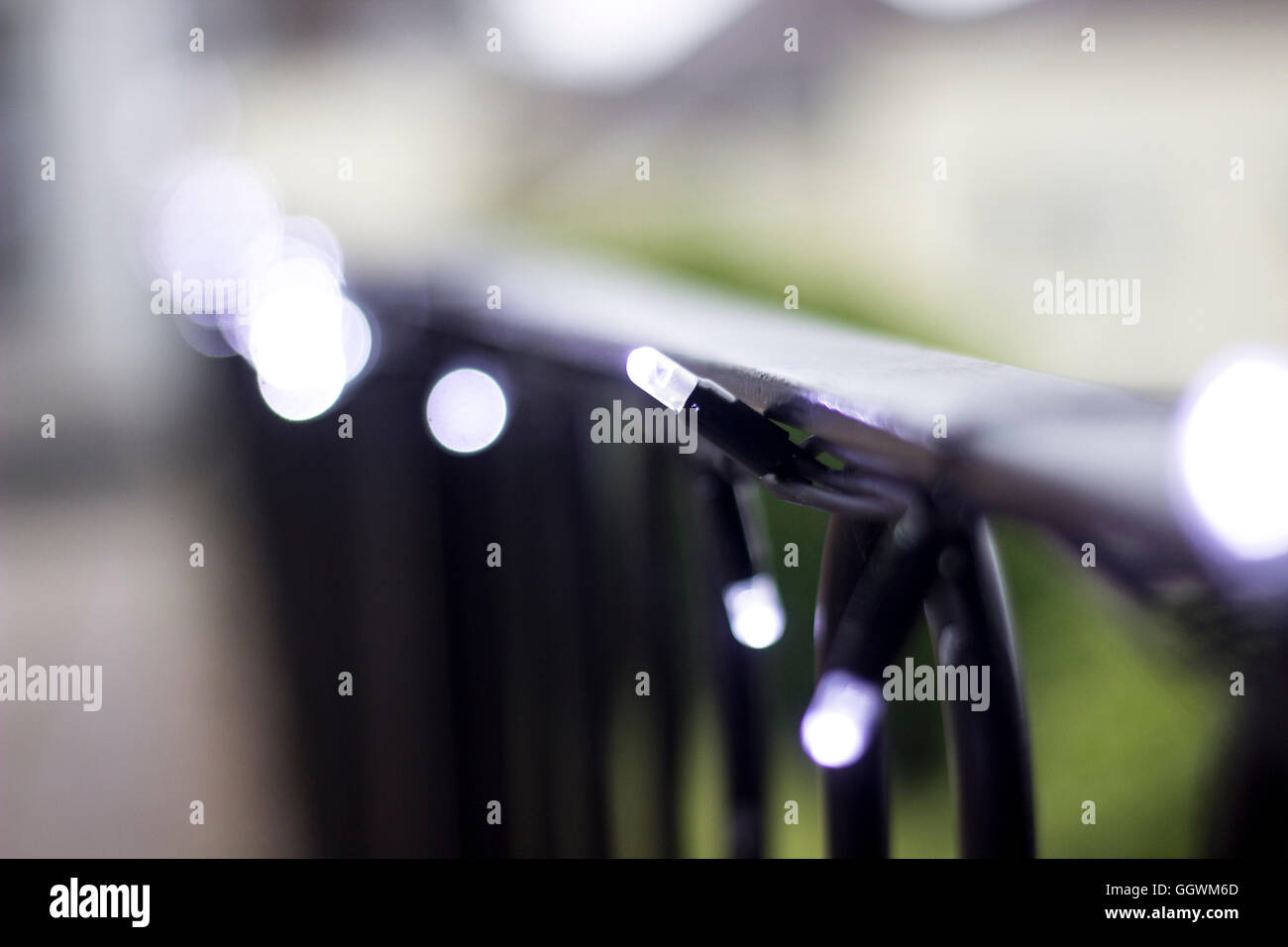 A close up, artistic shot of fairy lights, wrapped around a banister in ...