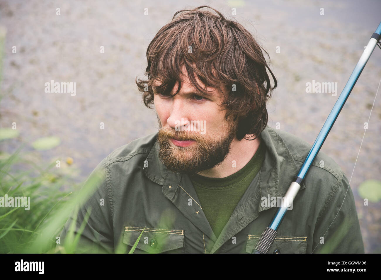 Young Man Fisherman bearded curly hair portrait standing with rod ...