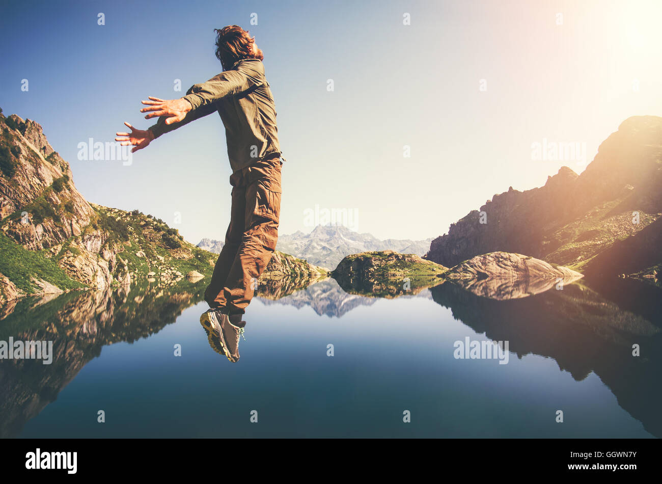 Happy Man Flying levitation jumping with lake and mountains on ...