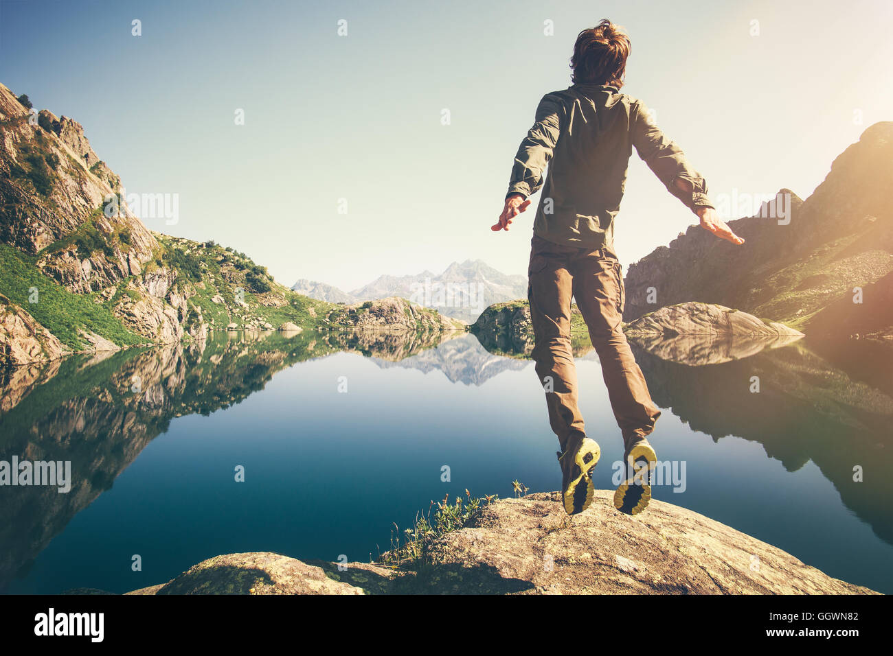 Man jumping Flying levitation with lake and mountains on background ...