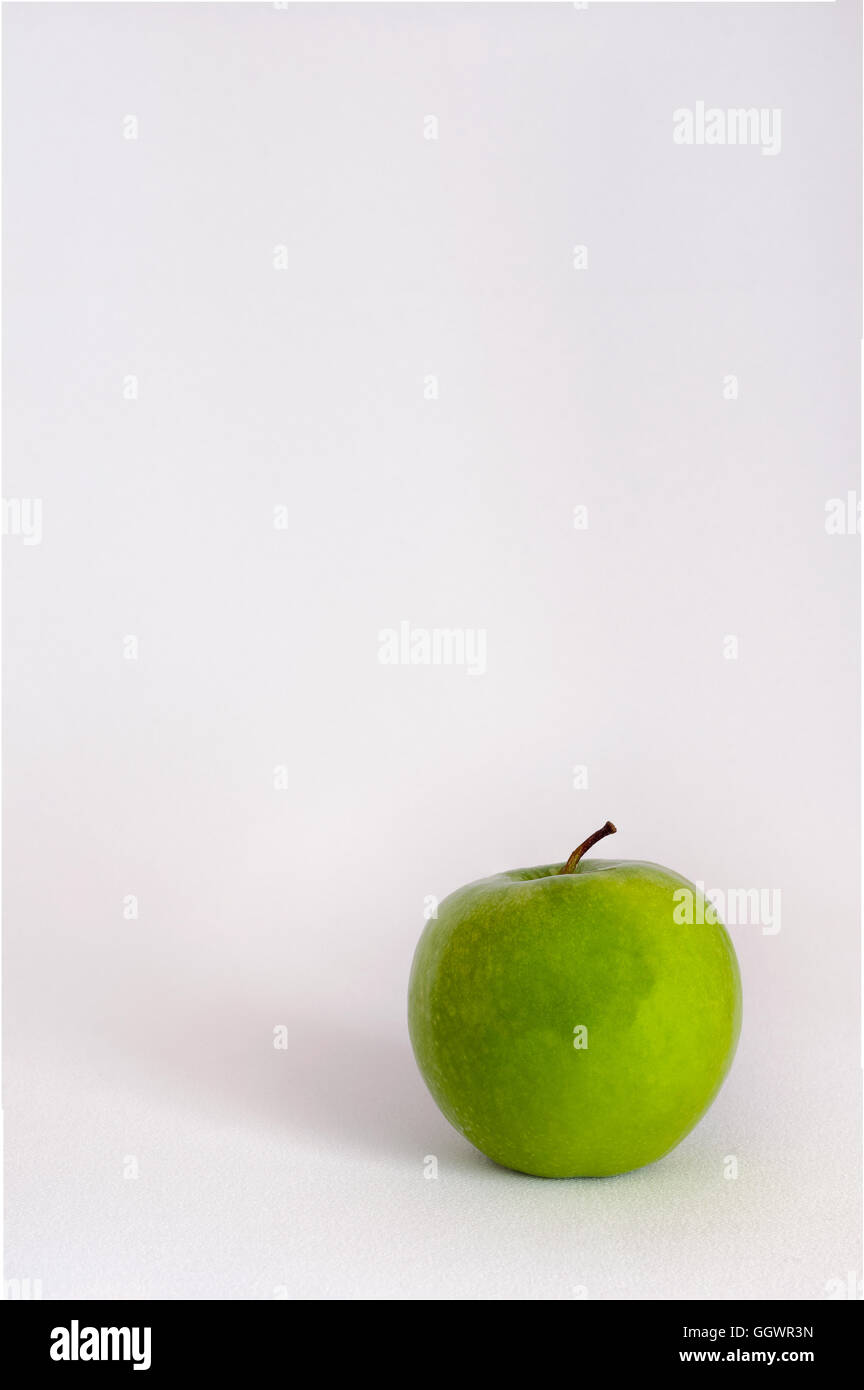 Single green apple, lower right of page with white background Stock ...