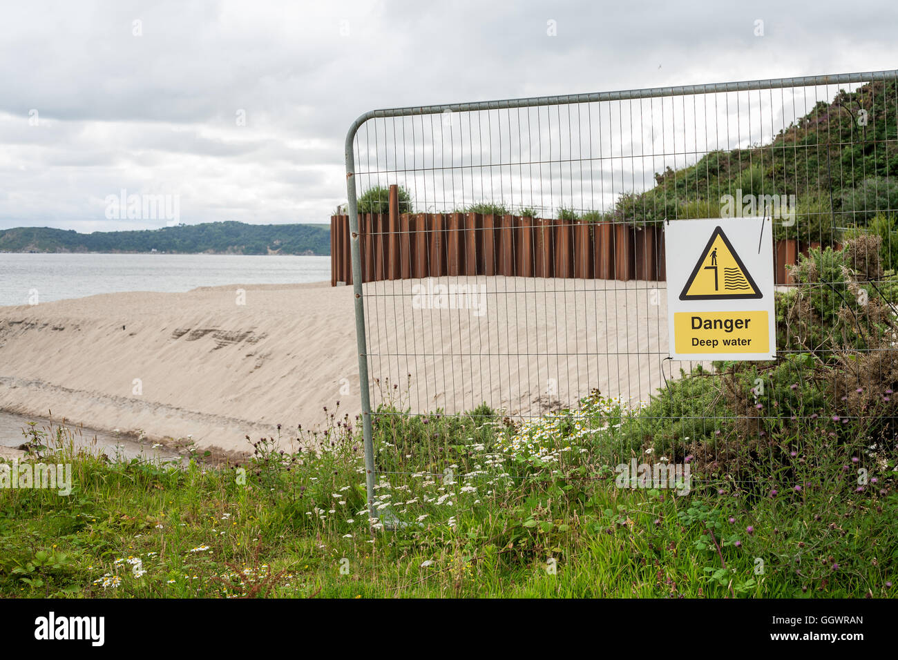 Danger Deep Water Public Warning Sign on Metal Fence with sandy beach ...