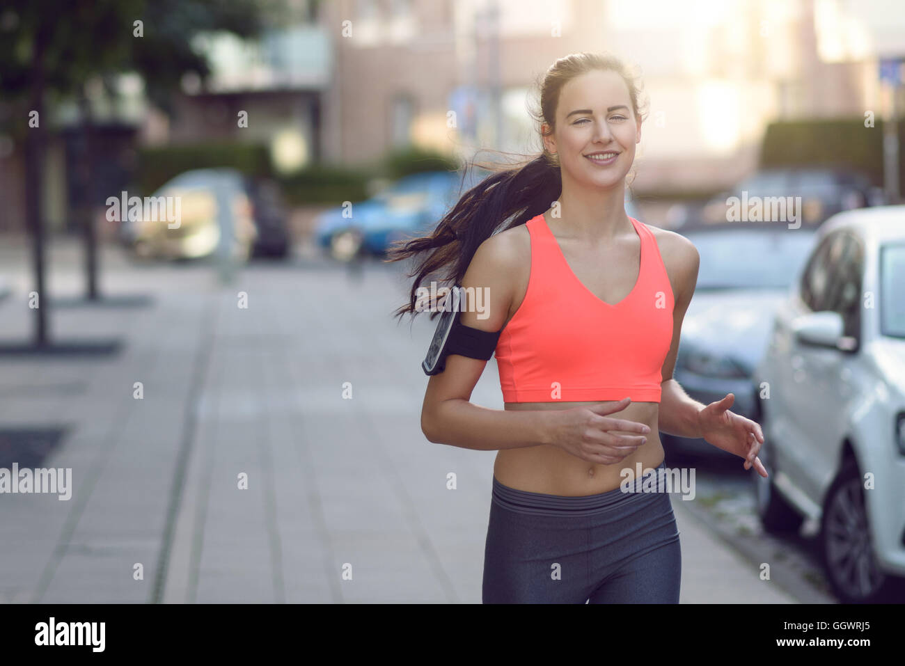 Fit young woman jogging along an urban street Stock Photo - Alamy