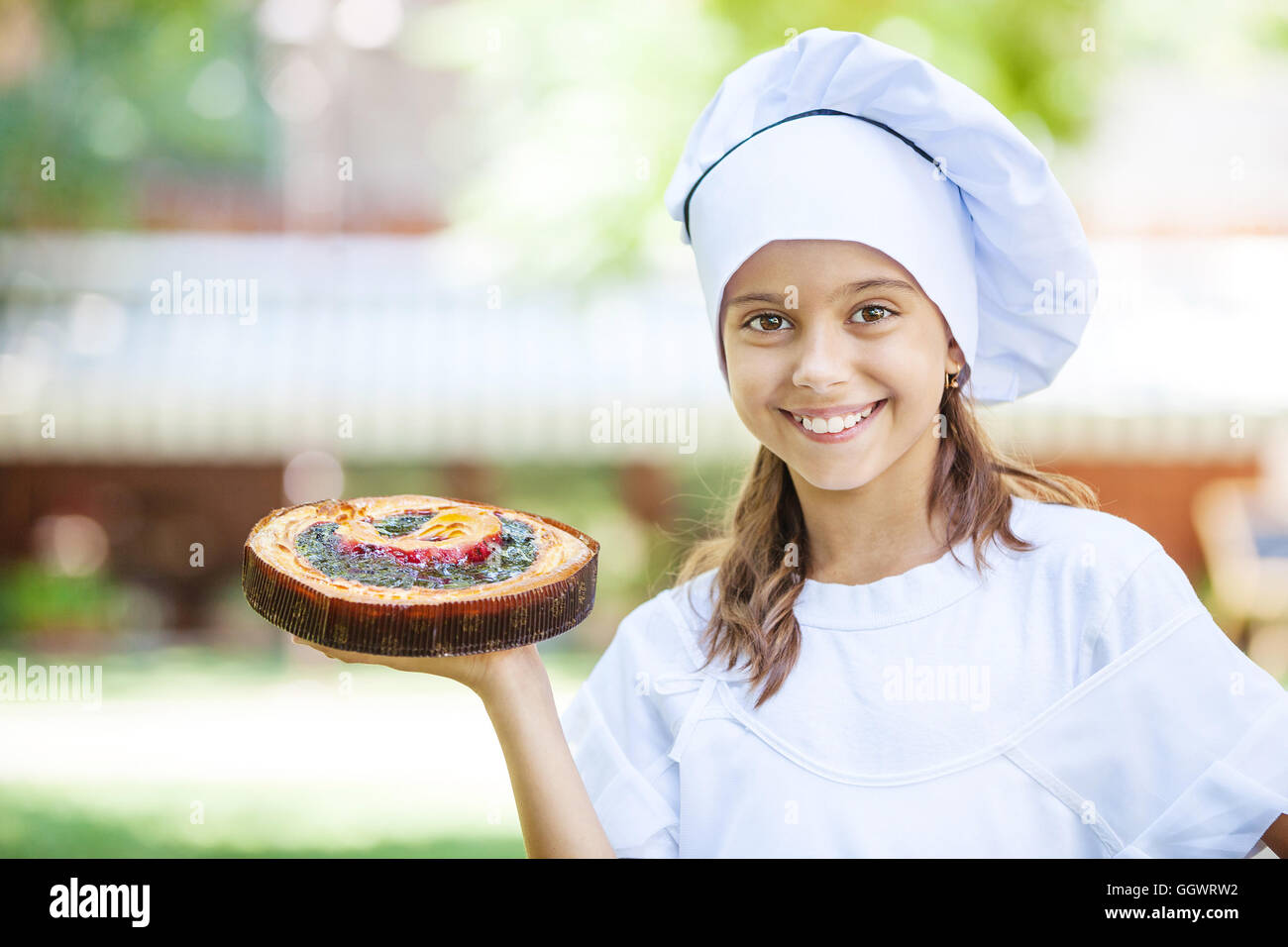 Young girl in chef's uniform holding pie Stock Photo - Alamy