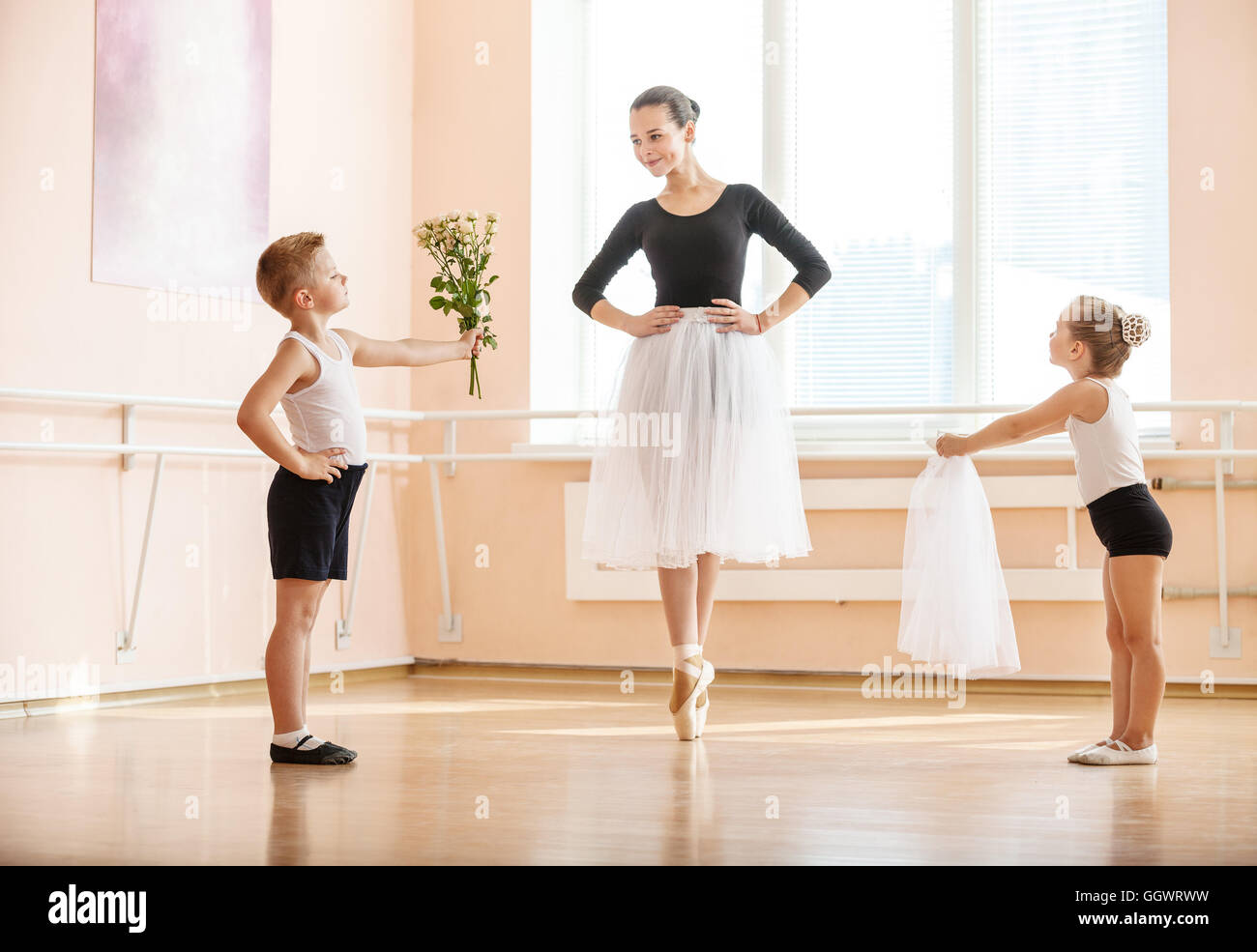 At ballet dancing class: young boy and girl giving flowers and veil to ...