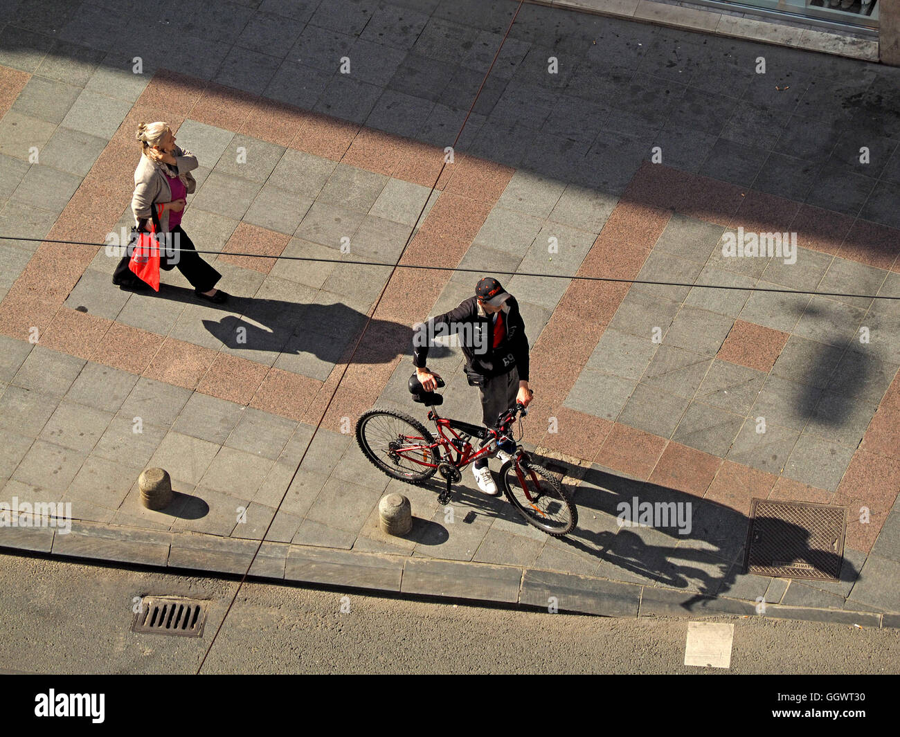 Overhead view of pedestrian and walking cyclist in main street Sarajevo ...