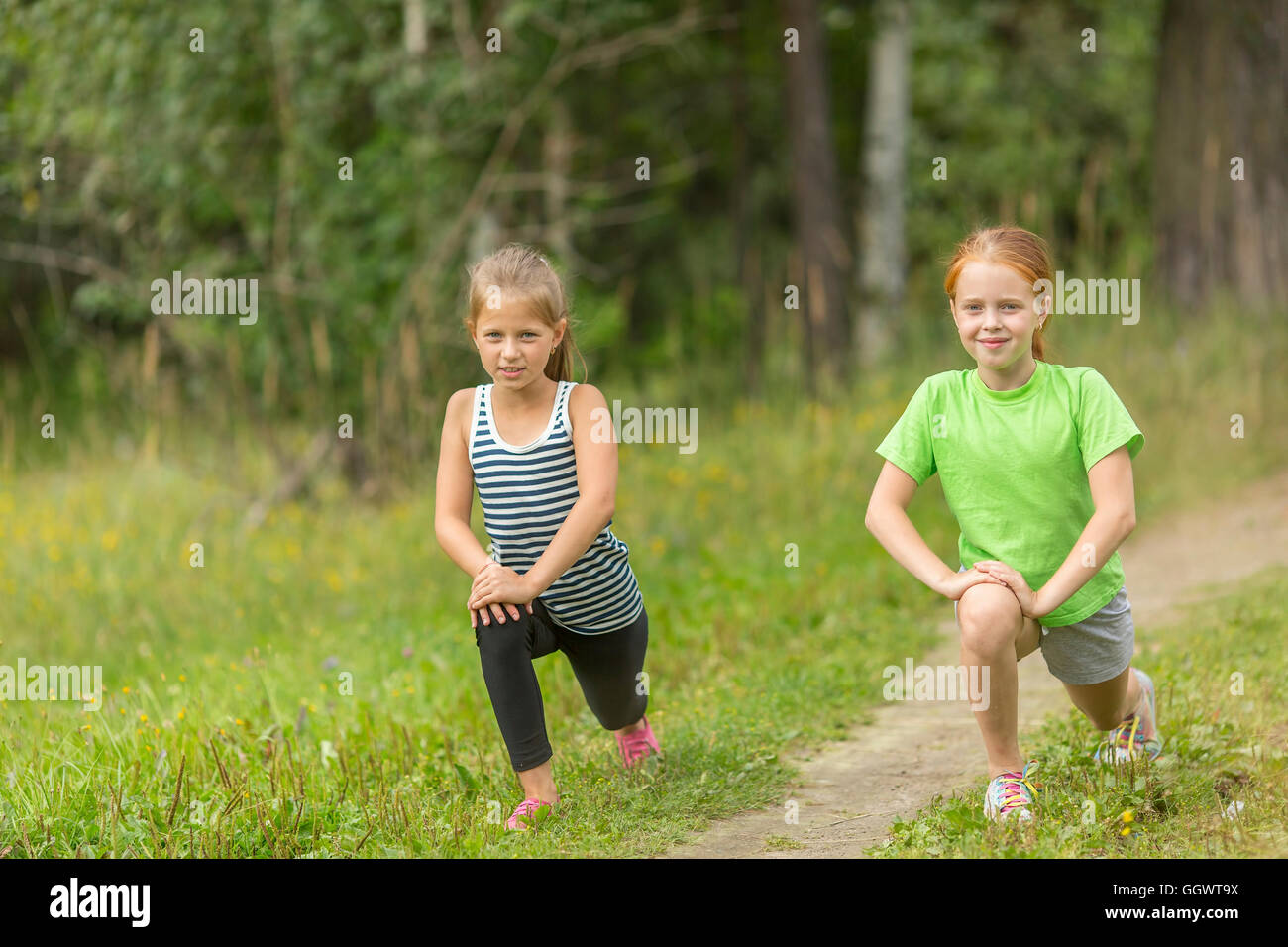 Two little cute girls warming up outdoors. Morning exercises Stock ...
