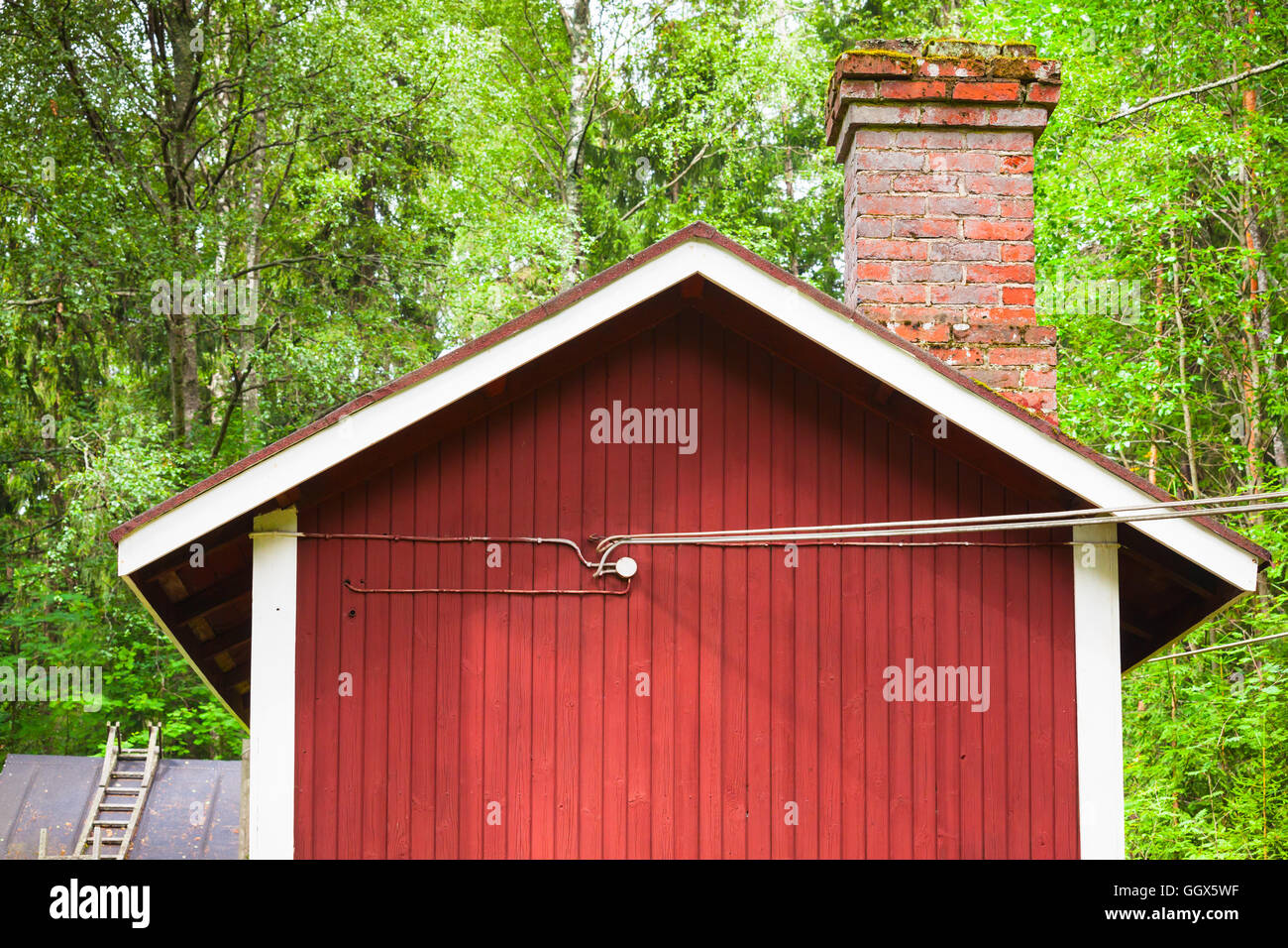 Facade fragment of traditional Scandinavian red wooden house over green ...