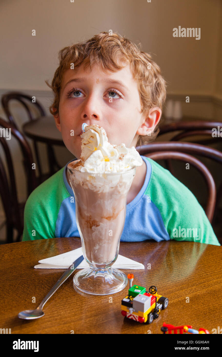Seven year old boy with a large chocolate milkshake, Totnes, Devon ...