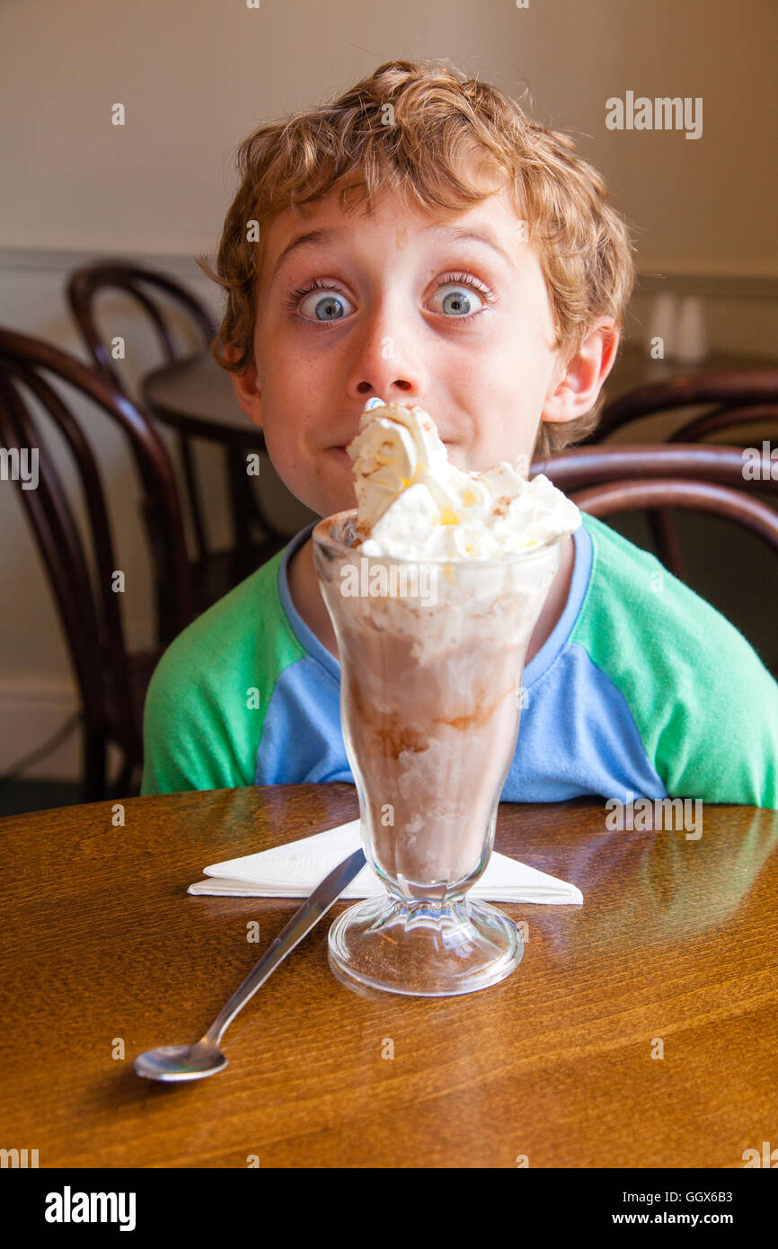 Seven year old boy with a large chocolate milkshake hi-res stock ...