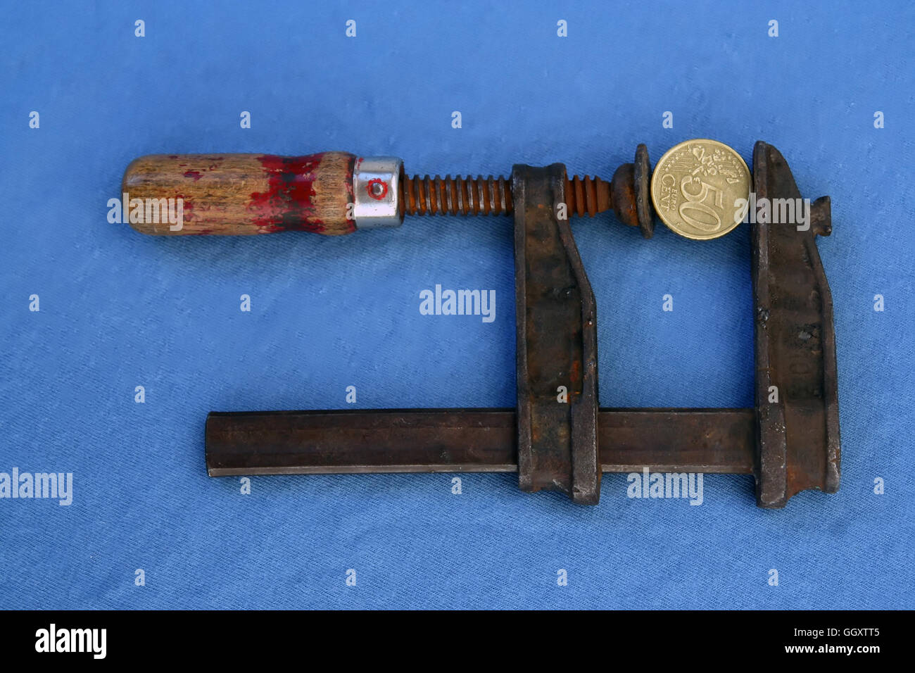 Euro coin in a clamp Stock Photo - Alamy