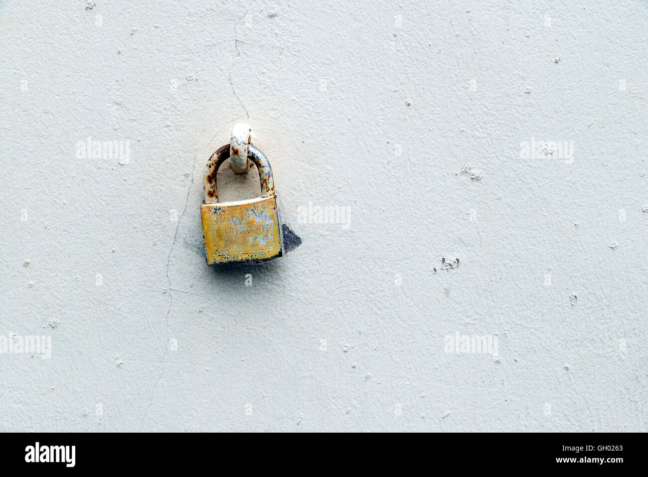 Old padlock on a wall painted white. Copy space Stock Photo - Alamy