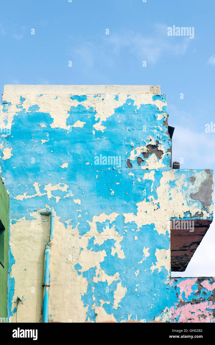 badly damaged facade of a house painted blue Stock Photo - Alamy