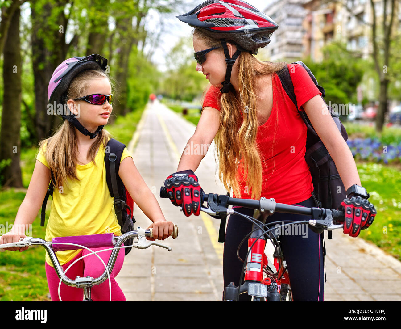 Girls children cycling on yellow bike lane Stock Photo - Alamy