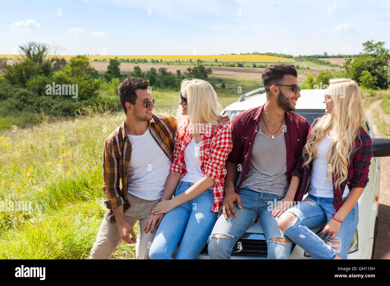 Friends sitting on car outdoor countryside people smile Stock Photo - Alamy