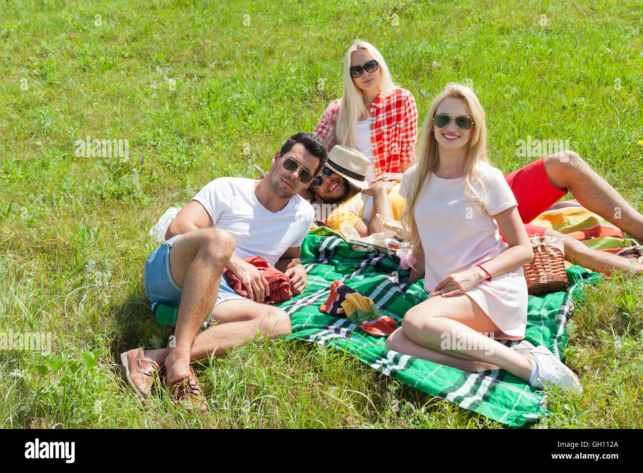 Friends picnic people group sitting blanket outdoor green grass Stock ...
