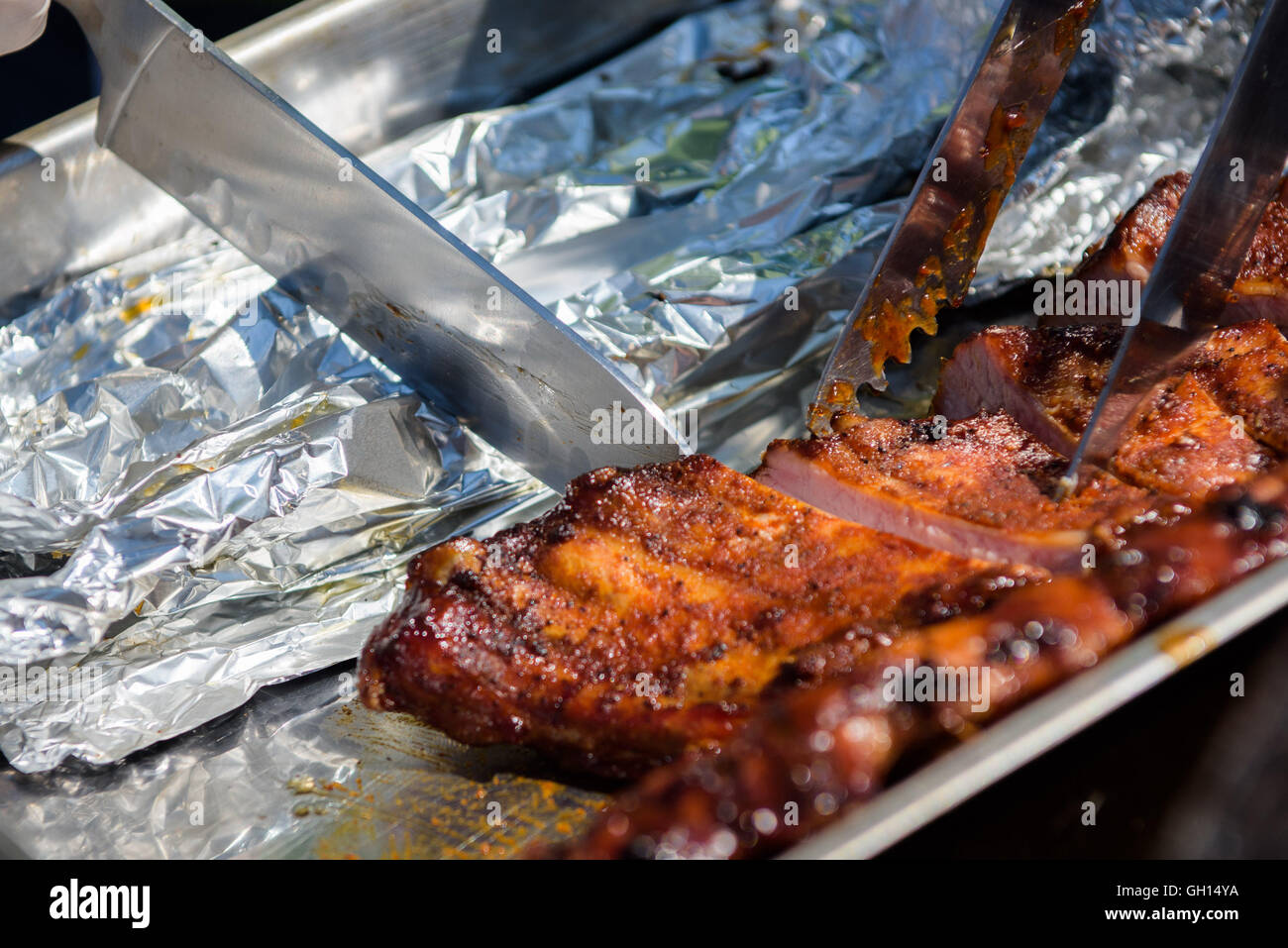 Fulda, Germany. 07th Aug, 2016. A participant cuts spare ribs during ...