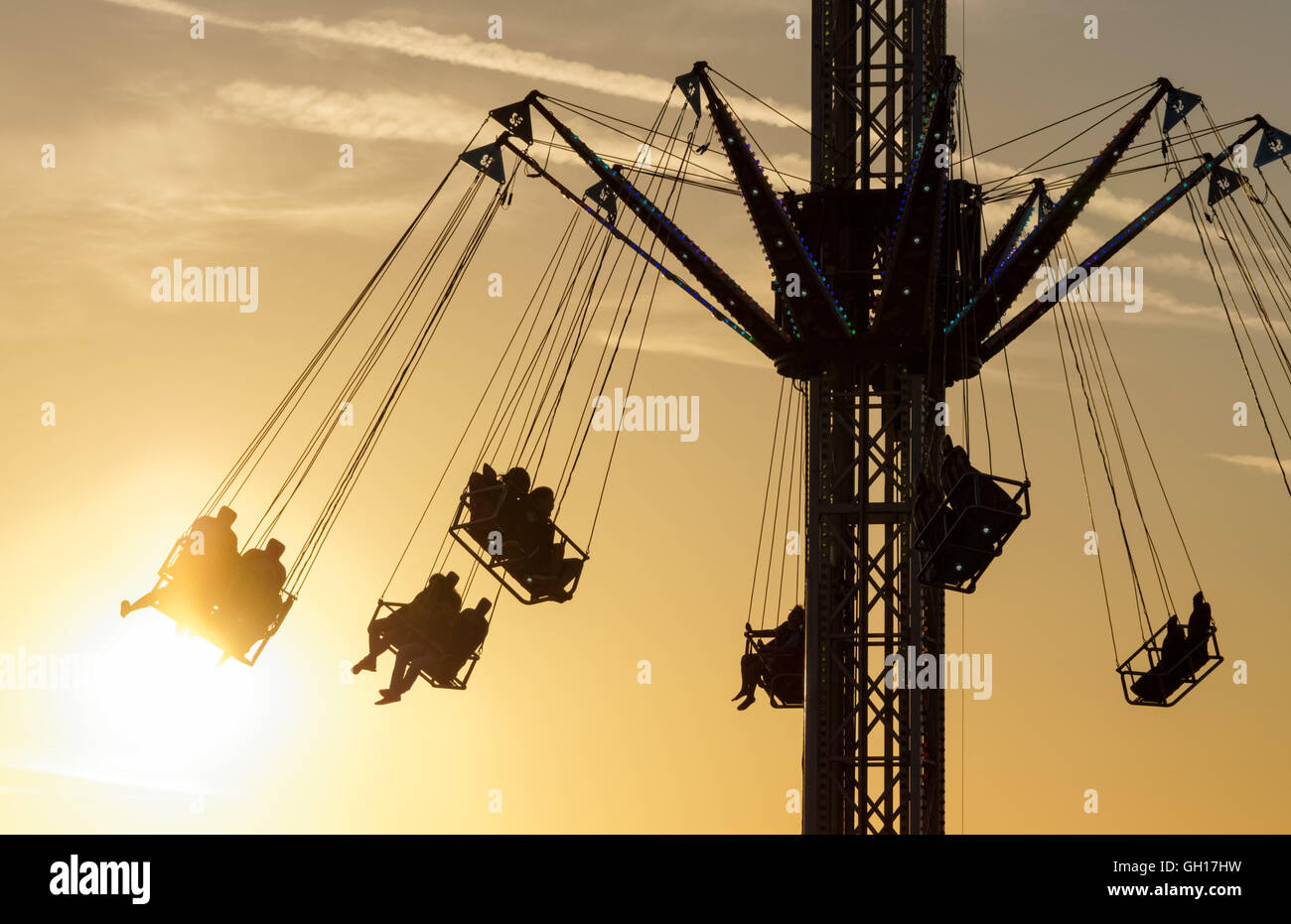 People enjoying swing ride at sunset Stock Photo - Alamy