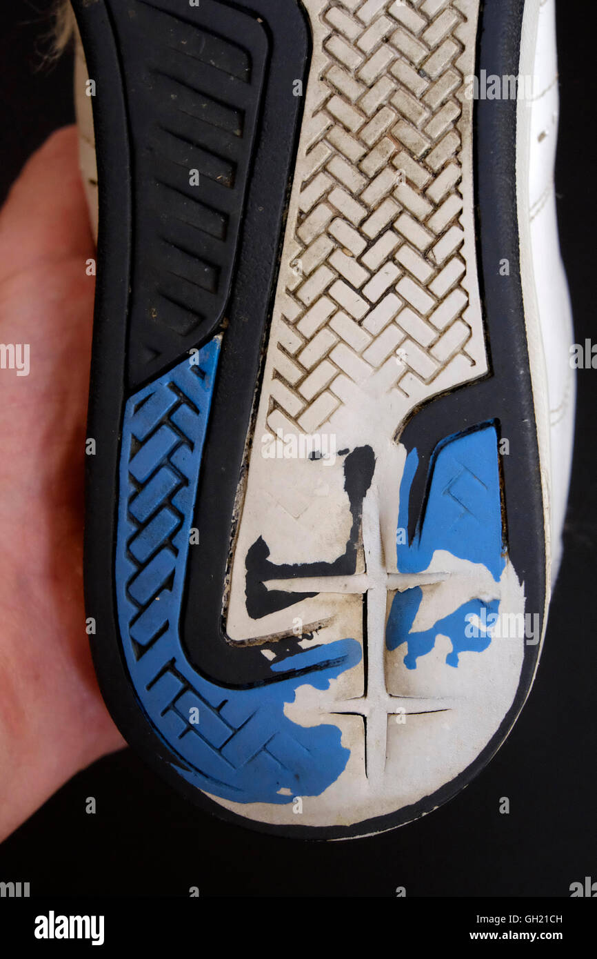 holes in the sole of a worn out training shoe Stock Photo - Alamy
